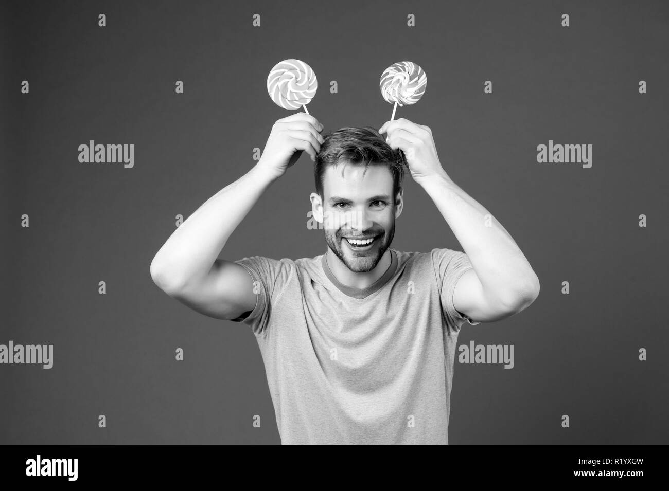 Lustiger Mann mit Lutscher auf Kopf auf violett unterlegt. Macho ...