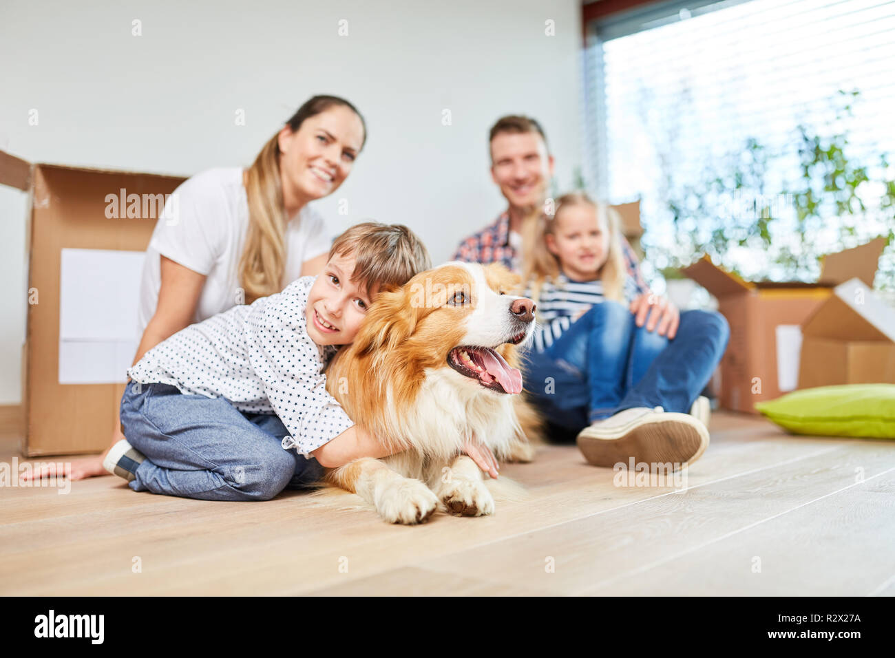 Familie mit Kindern und Hund glücklich im neuen Zuhause sitzen wie ein ...