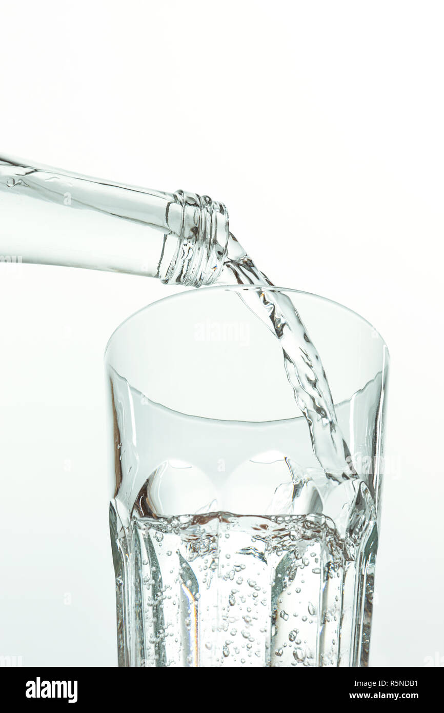 Das Gießen von Wasser aus Flasche in Glas und weiß Stockfotografie - Alamy