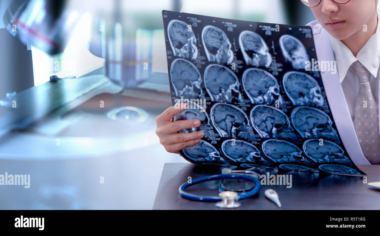 Junge Ärztin holding MRI oder CT-Bild, Arzt in Uniform sitzen im ...