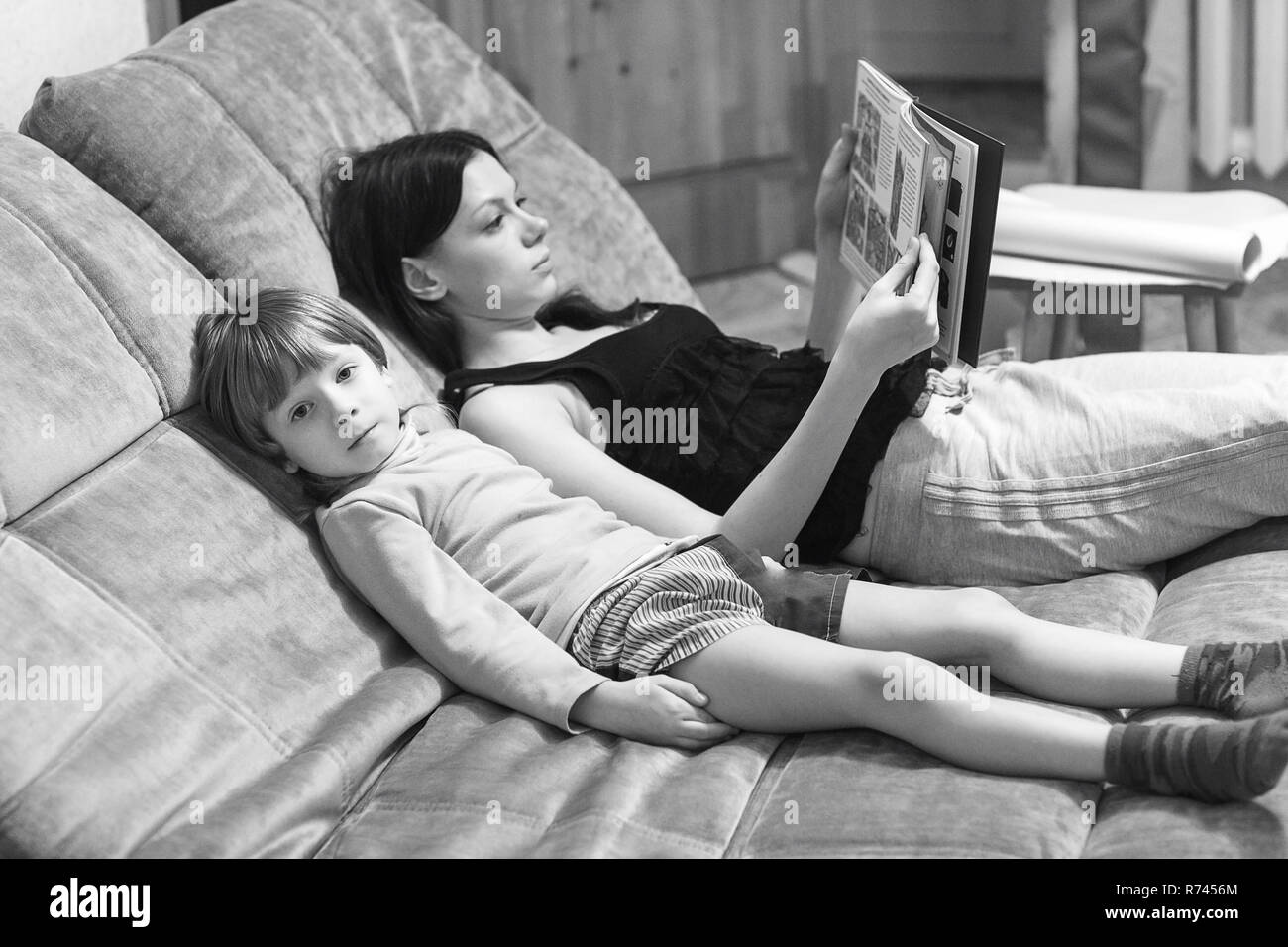 Die junge Mutter und ihr Sohn auf der Couch liegen und Geschichten aus ...