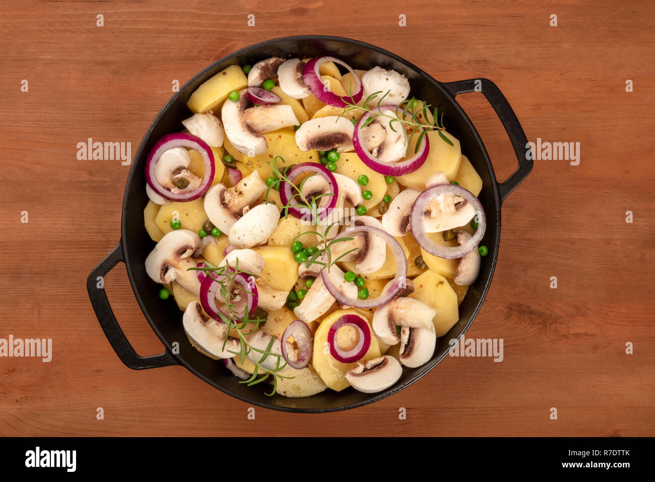 Eine Top-down-Foto von einem braiser mit rohem Gemüse, in Scheiben ...
