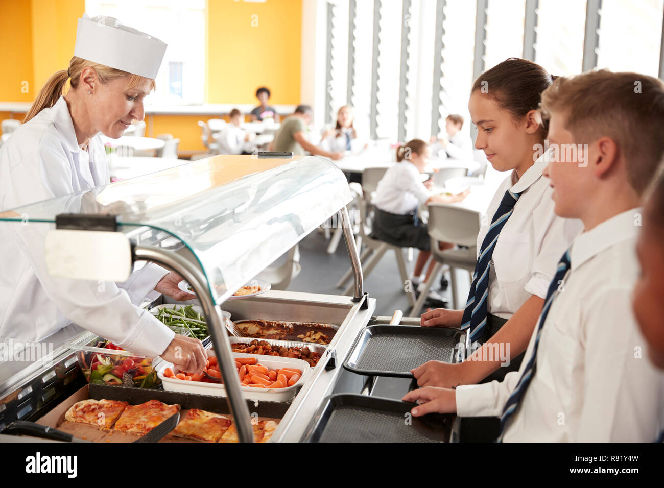 Schülerinnen und Schüler tragen Uniform, Essen in der Kantine ...