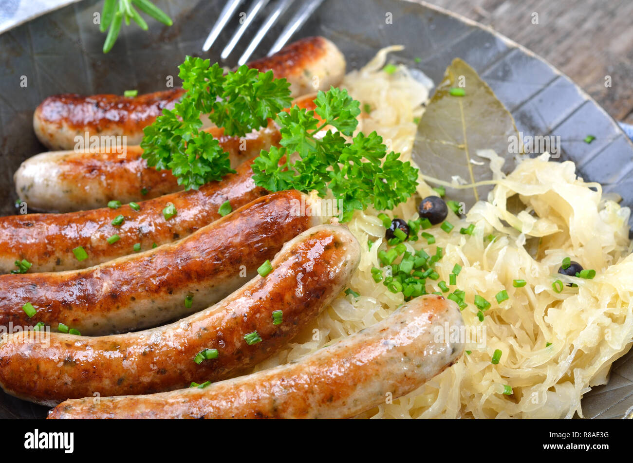 Leckere bayerische Wurst aus Nürnberg, serviert auf Sauerkraut in eine ...