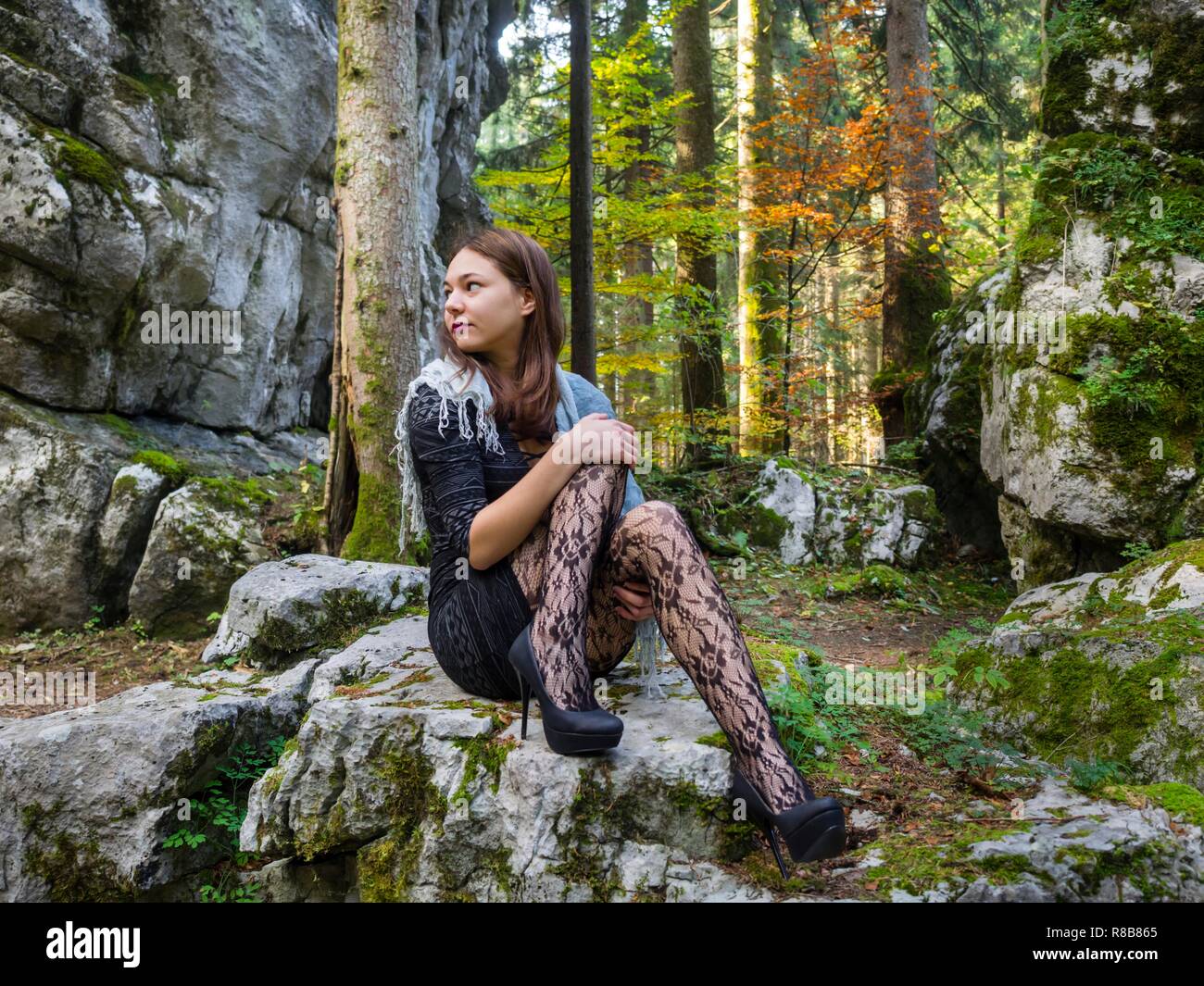 Schöne junge Frau in der Natur ist der sitzt auf Big Rock entfernt ... Schöne junge Frau in der Natur ist der sitzt auf Big Rock entfernt ...