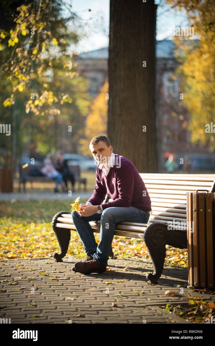 Mann sitzt auf bank unter baum in einem park -Fotos und -Bildmaterial ...