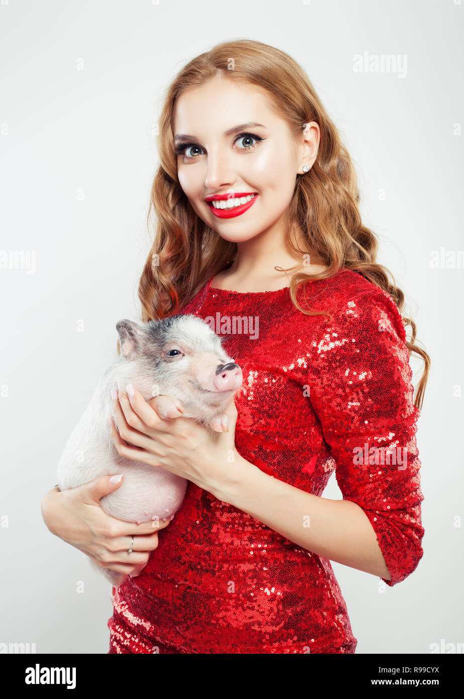 Hübsche junge Frau Kuscheln ein kleines Schwein auf weißem Hintergrund ...