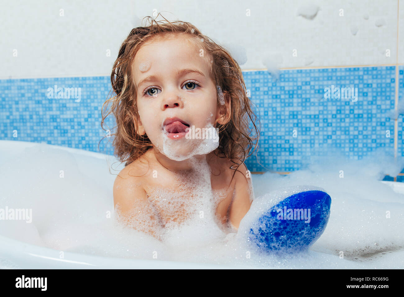 Wenig schöne Mädchen badet in einem Badezimmer, spielt der Narr und ...