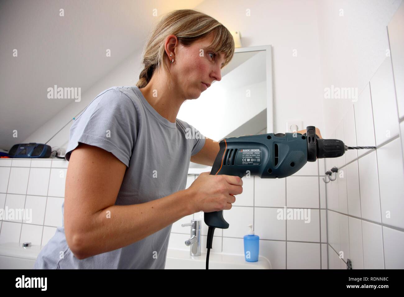 Frau loch bohren wand -Fotos und -Bildmaterial in hoher Auflösung – Alamy