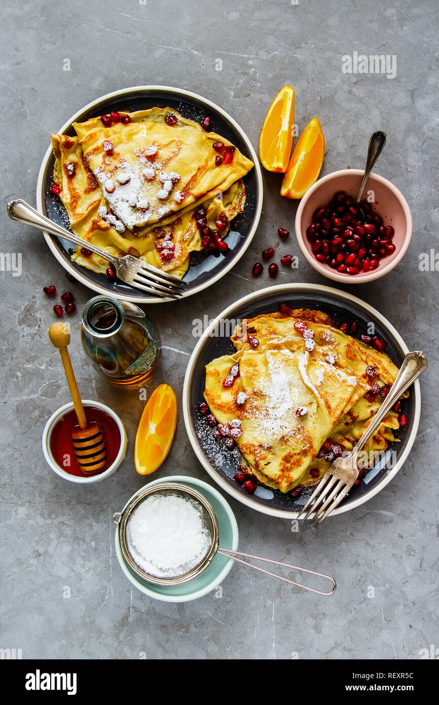 Flachbild-lay von süßen Crepes gefüllt mit Granatapfel. Dünne ...