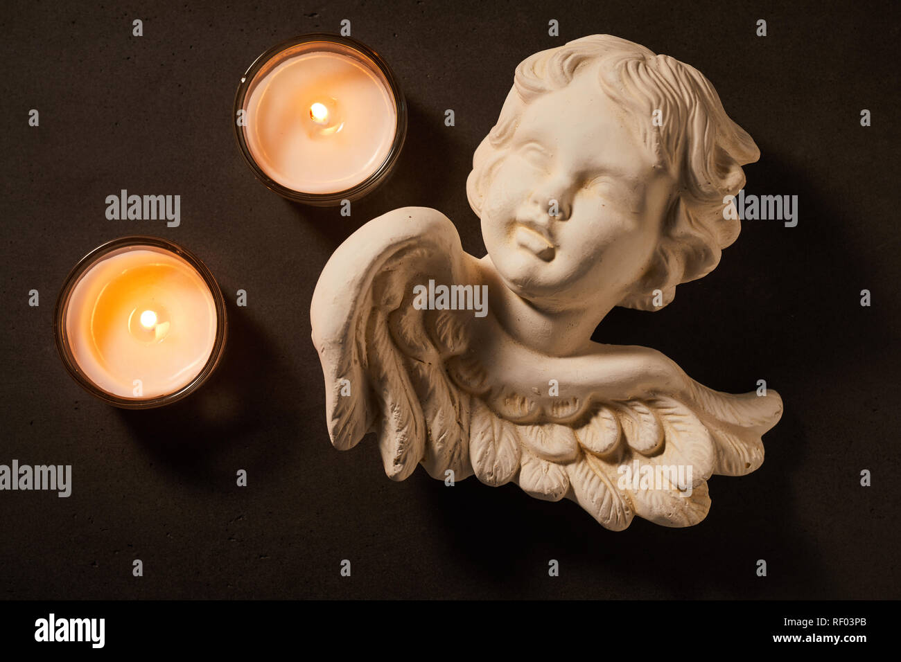 Engel der Putto mit brennenden Kerzen über einen dunklen Hintergrund ... Engel der Putto mit brennenden Kerzen über einen dunklen Hintergrund ...