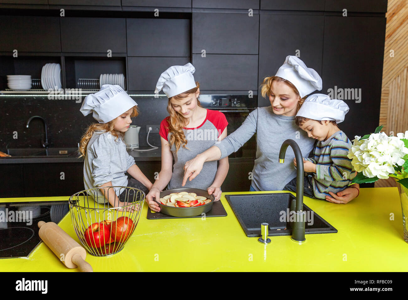 Glückliche Familie in der Küche. Mutter und drei Kinder Vorbereitung ...
