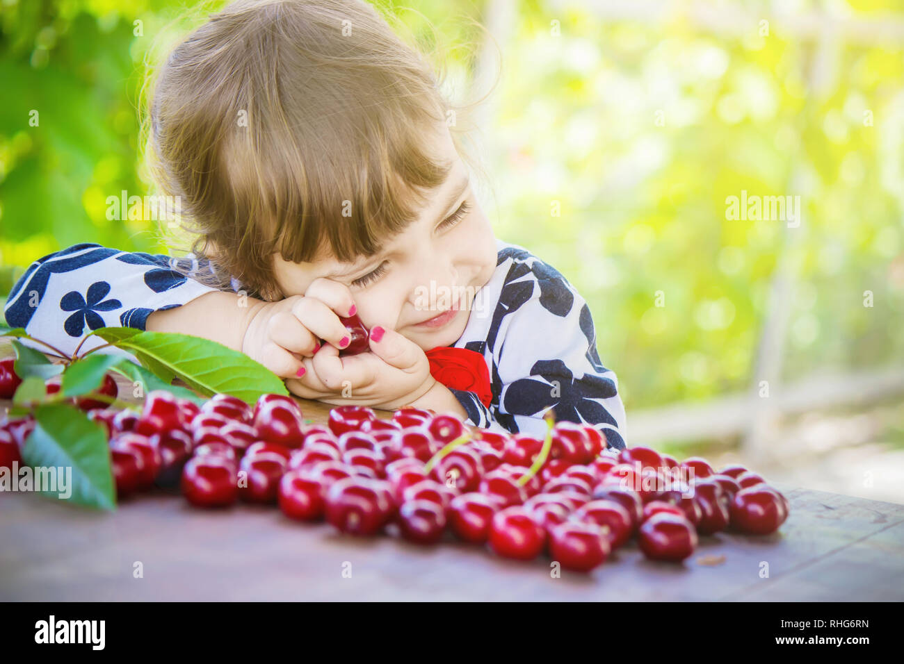 Das Kind ist die Ernte Kirschen in den Garten. Selektive konzentrieren ...