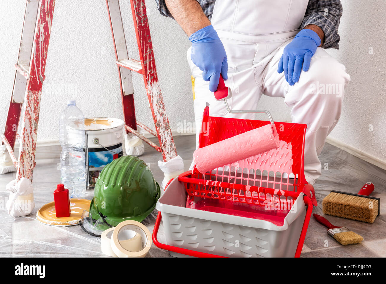 Kaukasische Haus Maler Arbeiter arbeiten in weißen Overalls, tauchen ...