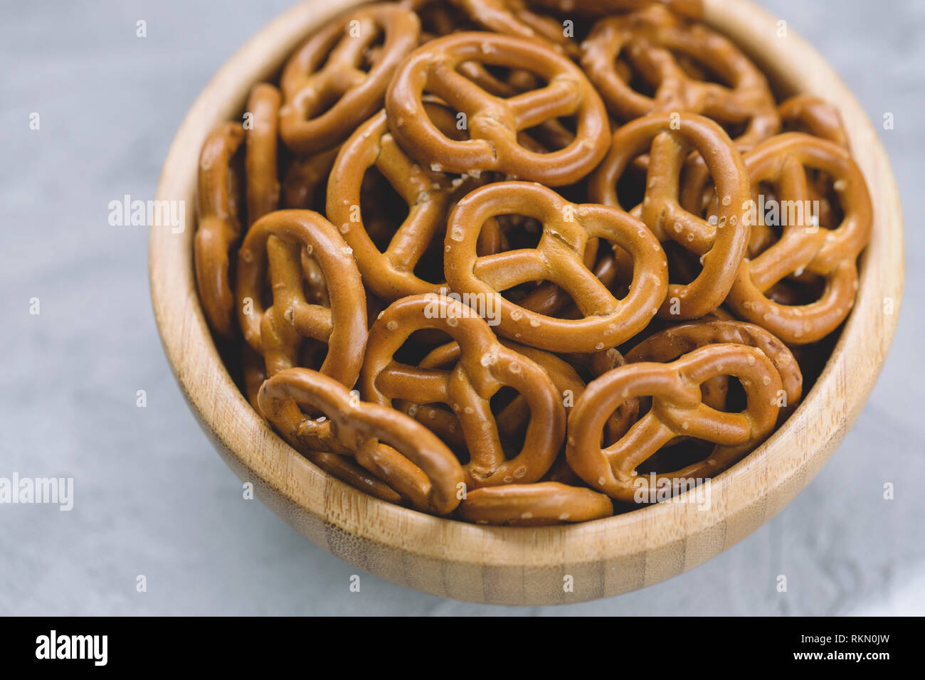 Traditionelle salzig mini Brezel in Houten auf grauem Hintergrund ...