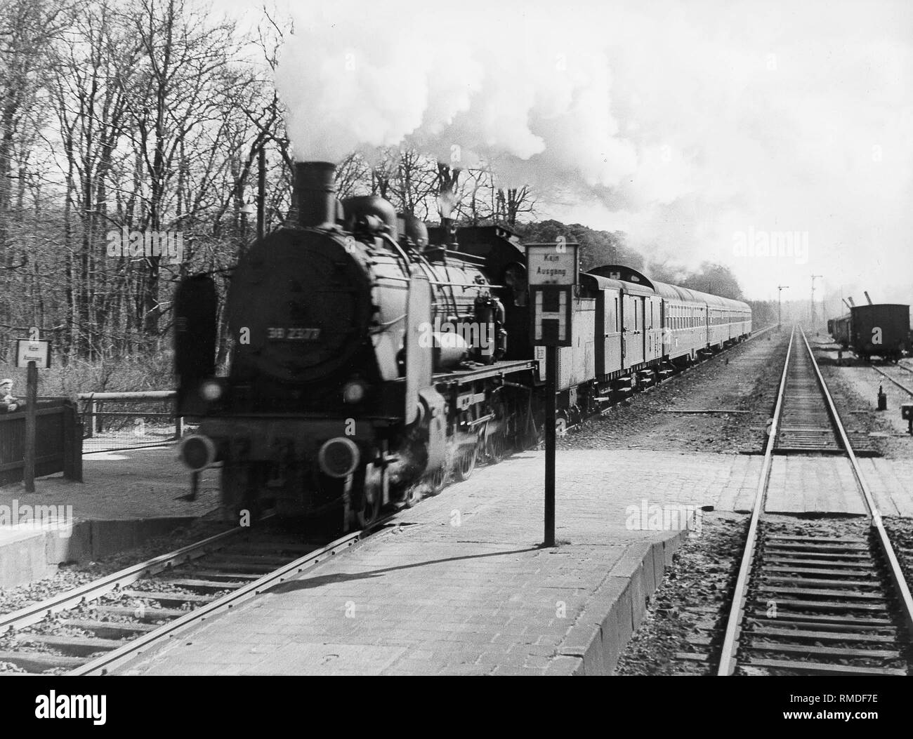 Ein D-Zug von einer Dampflokomotive durch einen Bahnhof in ...