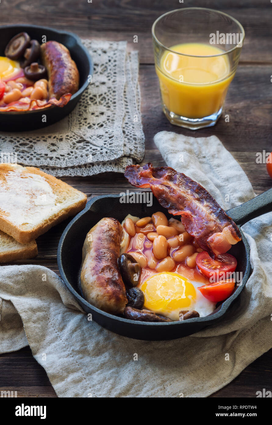 Gebratene Eier, Würstchen, Speck, Bohnen und Champignons in Iron ...
