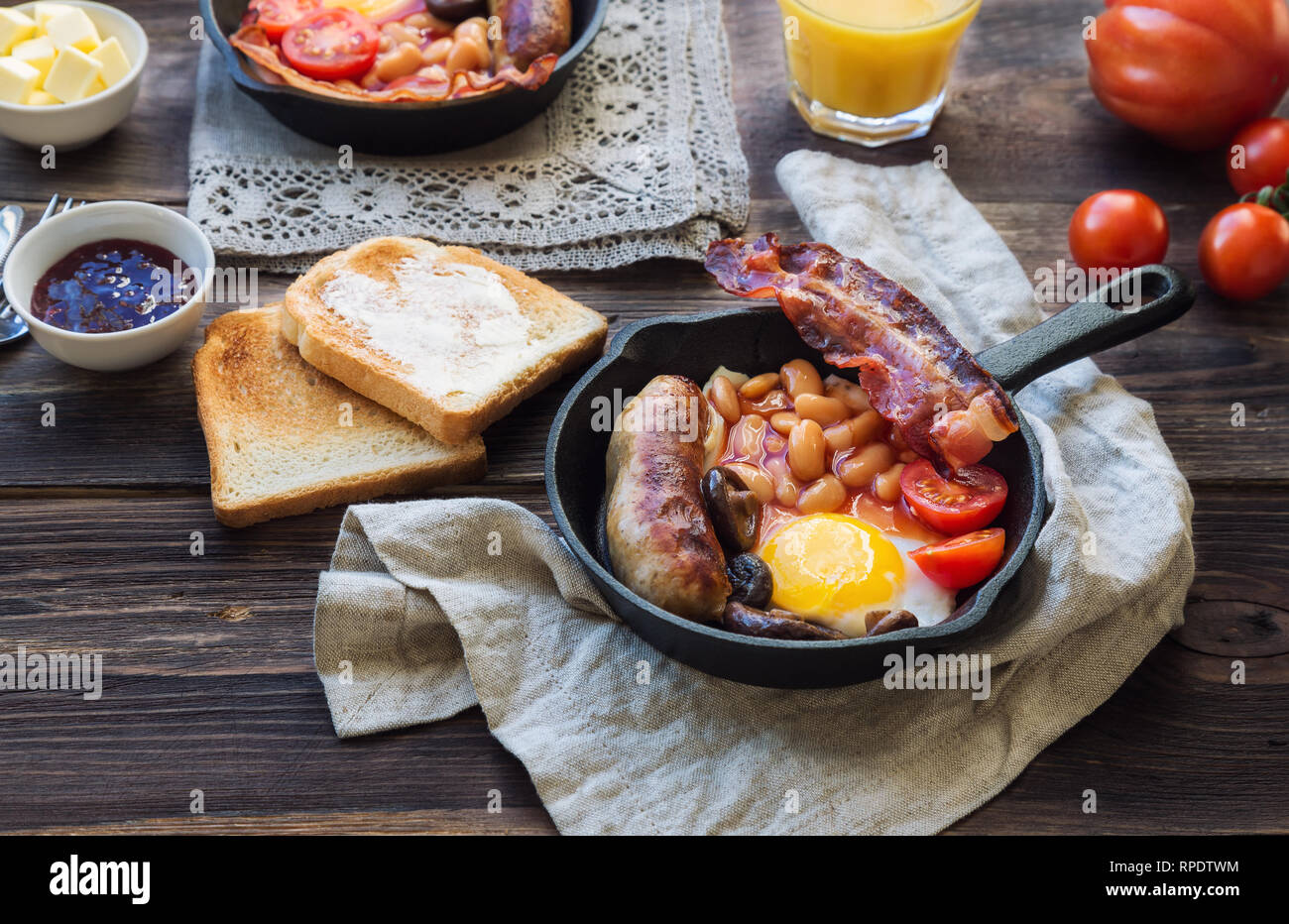Gebratene Eier, Würstchen, Speck, Bohnen und Champignons in Iron ...