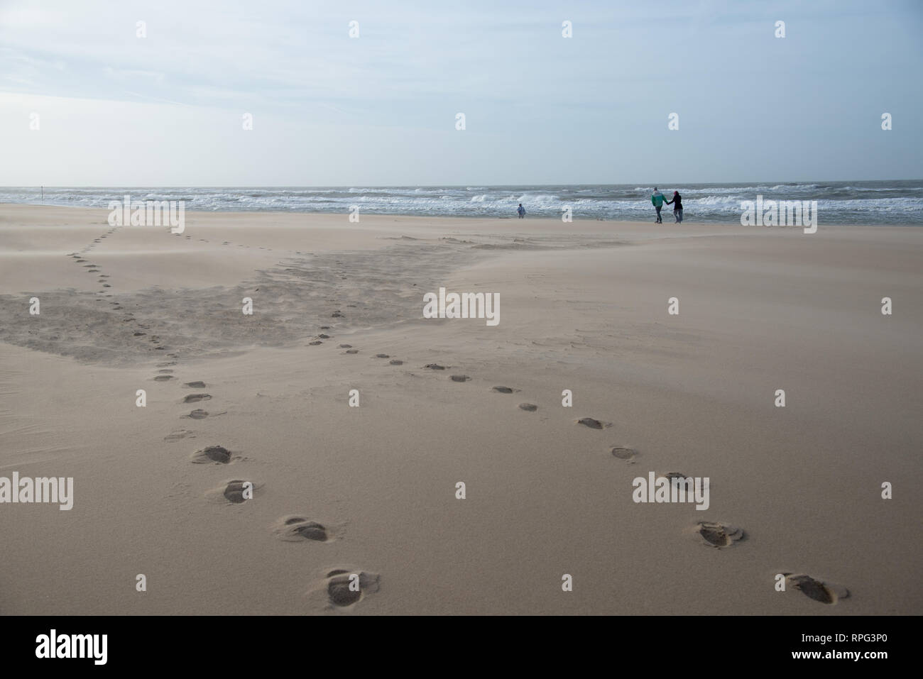 Menschen und Schritte im Sand am Strand in Holland in einem Sturm ...