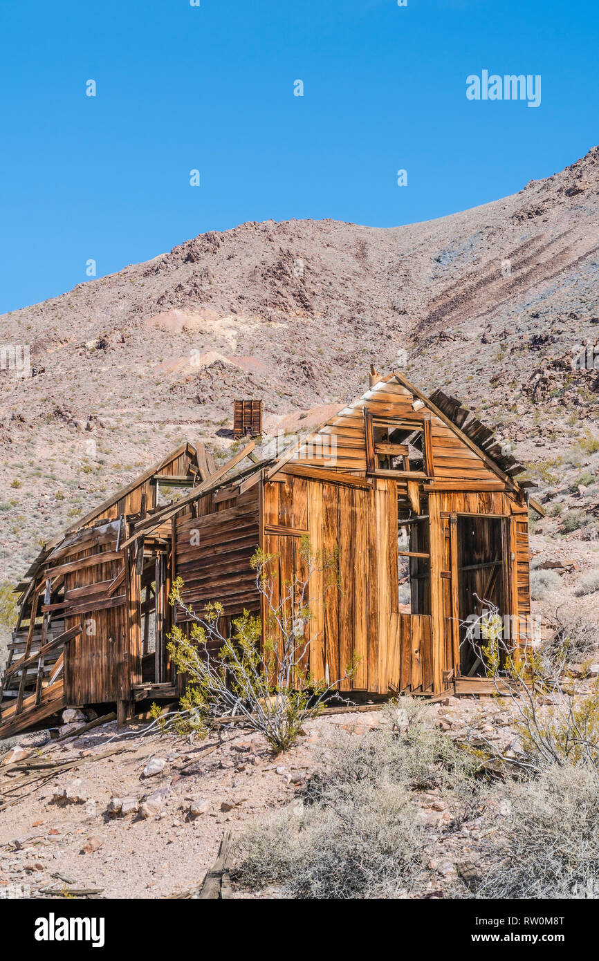 Ein Holzhaus mit einem eingestürzten Dach an den Inyo Mine Ruinen im Death Valley. Den Inyo Mine ...