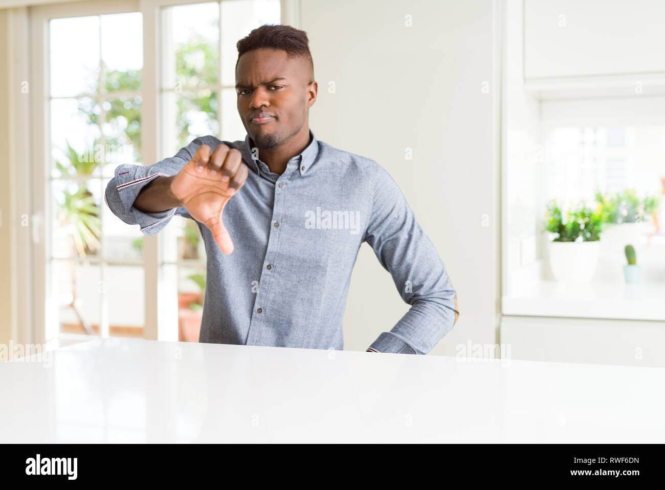 Stattliche african american man am weißen Tisch suchen unzufrieden und ...