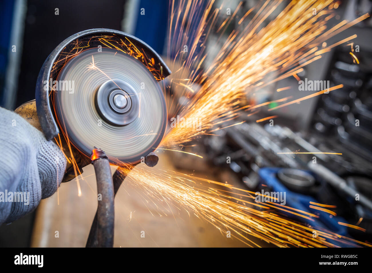Ein junger Mann, der Schweißer auf einer weißen Handschuhen Grinder ...