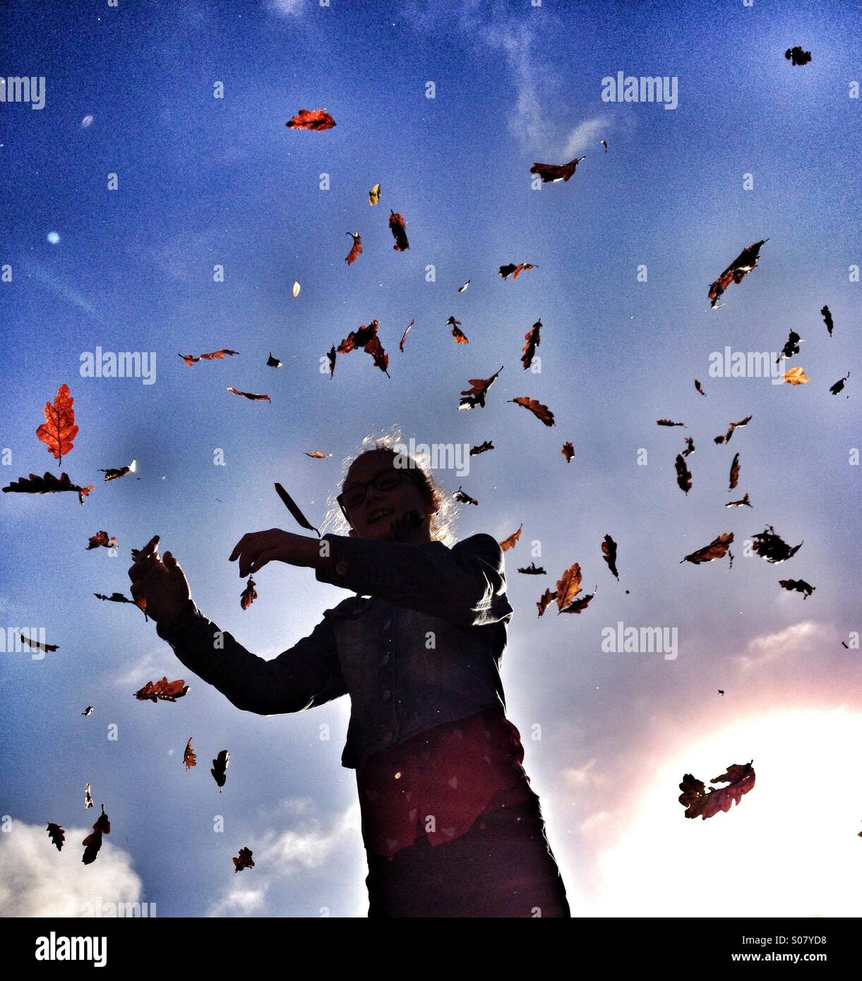 Junges Mädchen mit Herbstblätter fallen um sie herum Stockfotografie ...