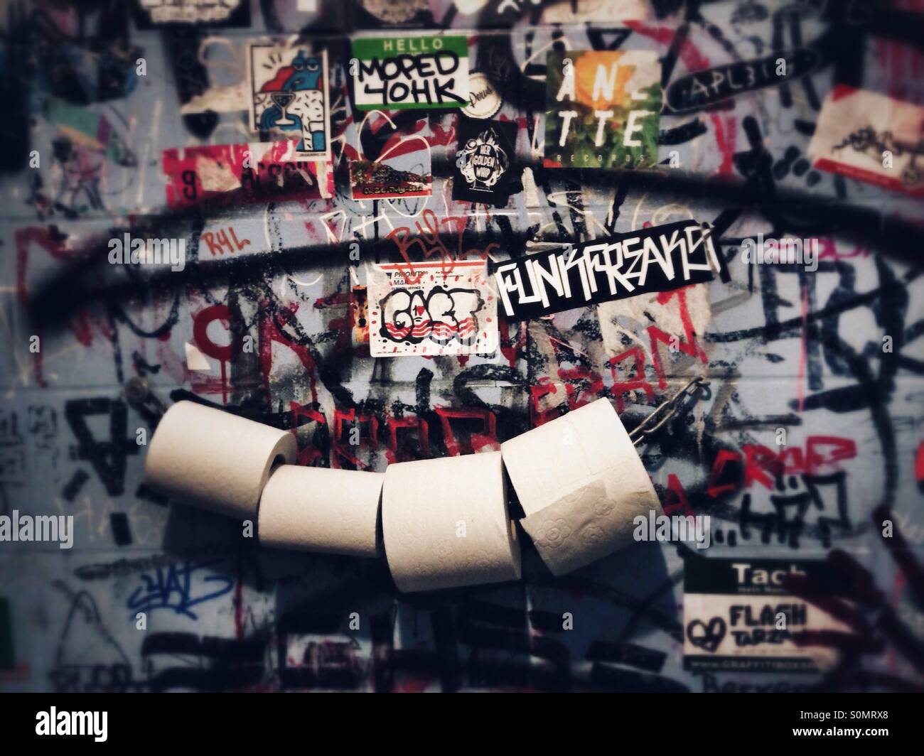 WC-Papier an der Wand voll mit Aufklebern, Graffiti und Tags in einer ...