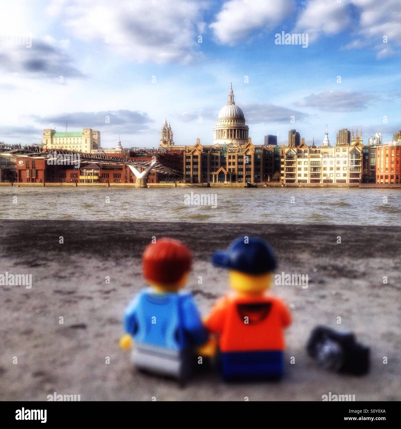Ein Lego-paar sitzt an der Themse mit Blick auf die Skyline von London ...