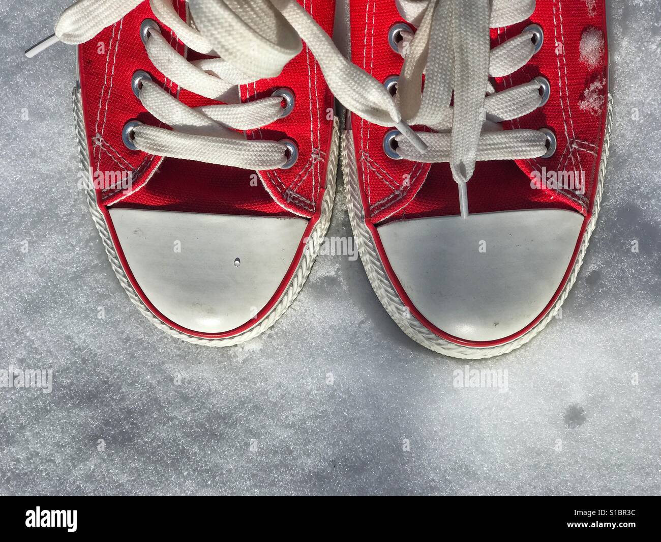 Rote Turnschuhe auf dem weißen Schnee, Ansicht von oben Stockfotografie ...