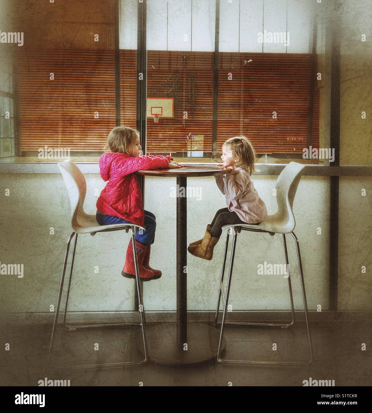 Kind sitzt auf einem tisch kind sitzt auf einem tisch -Fotos und ...