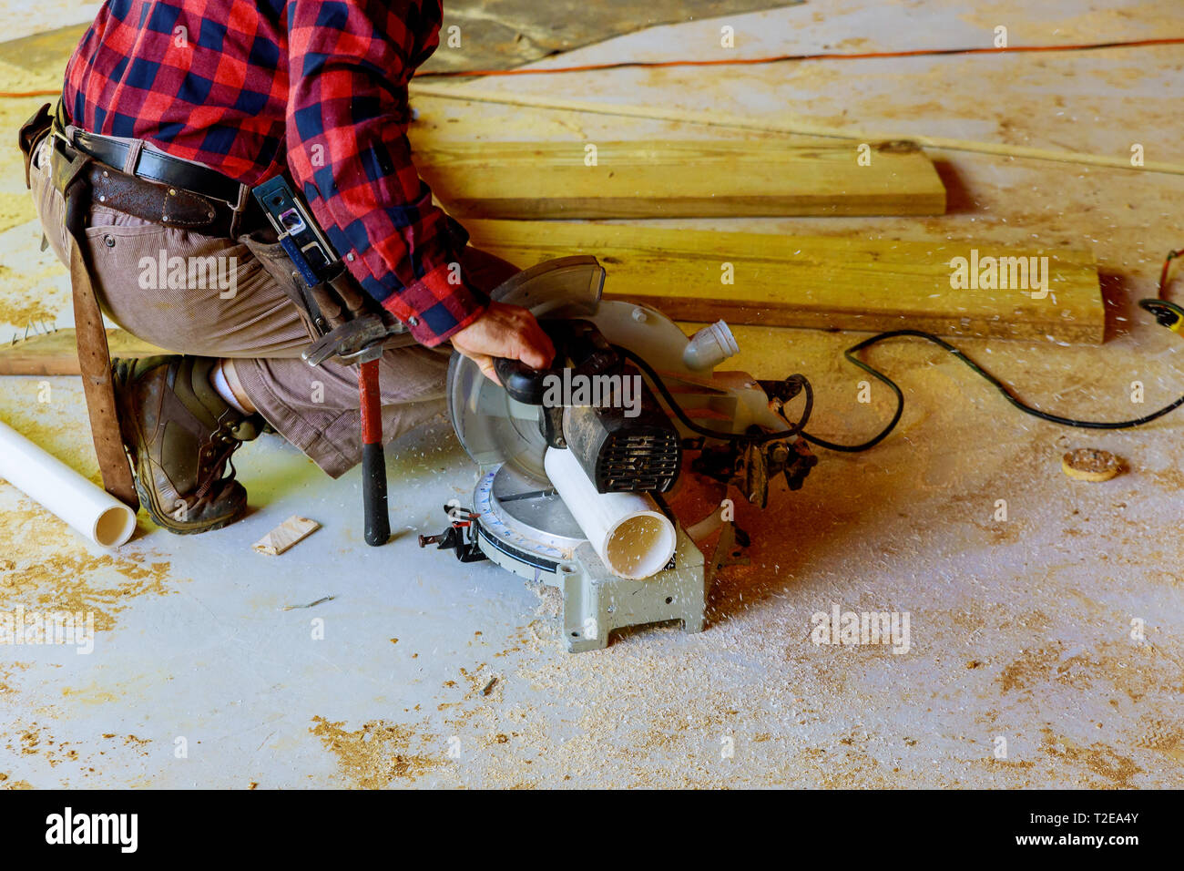 Arbeitnehmer mit elektrische Säge schneiden PVC-Rohr in den Bau eines ...