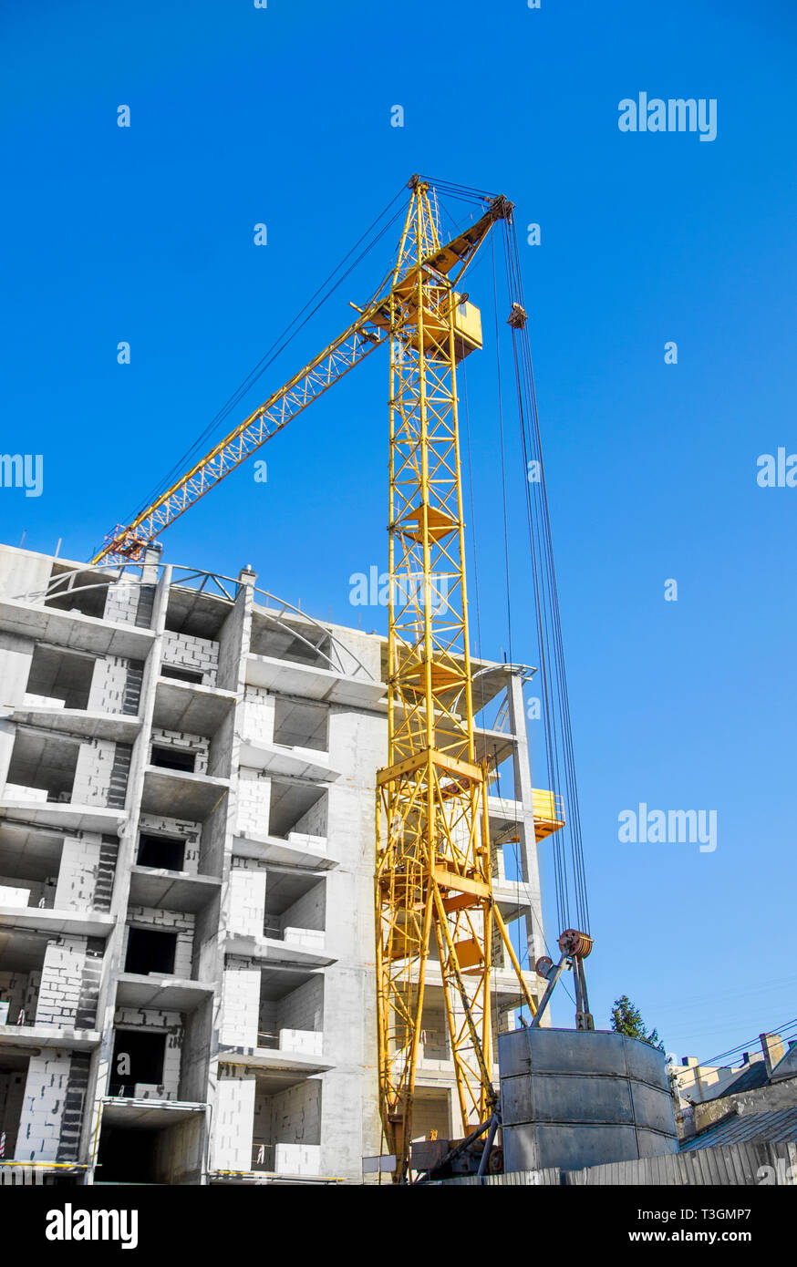 Gelbe bau Kran auf einer Baustelle in der Nähe von einem unfertigen ...