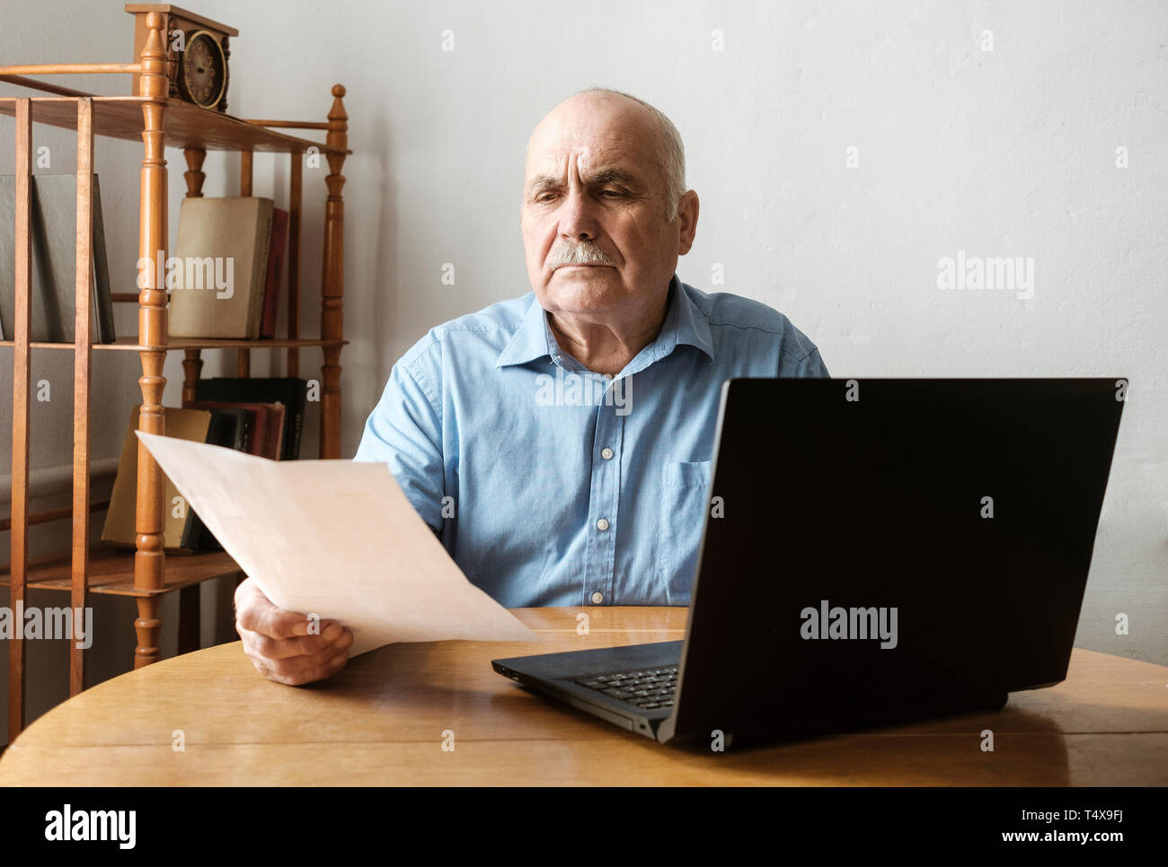 Ein mann sitzt an einem tisch mit einem laptop -Fotos und -Bildmaterial ...