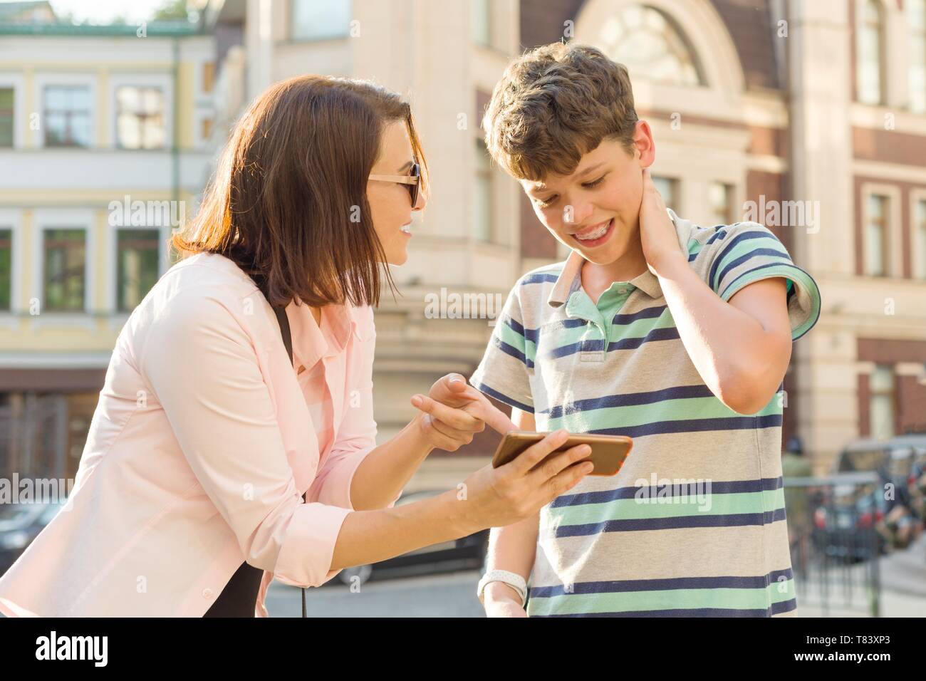 Eltern und Teenager, Beziehung. Die Mutter ihrem Sohn etwas im Handy ...