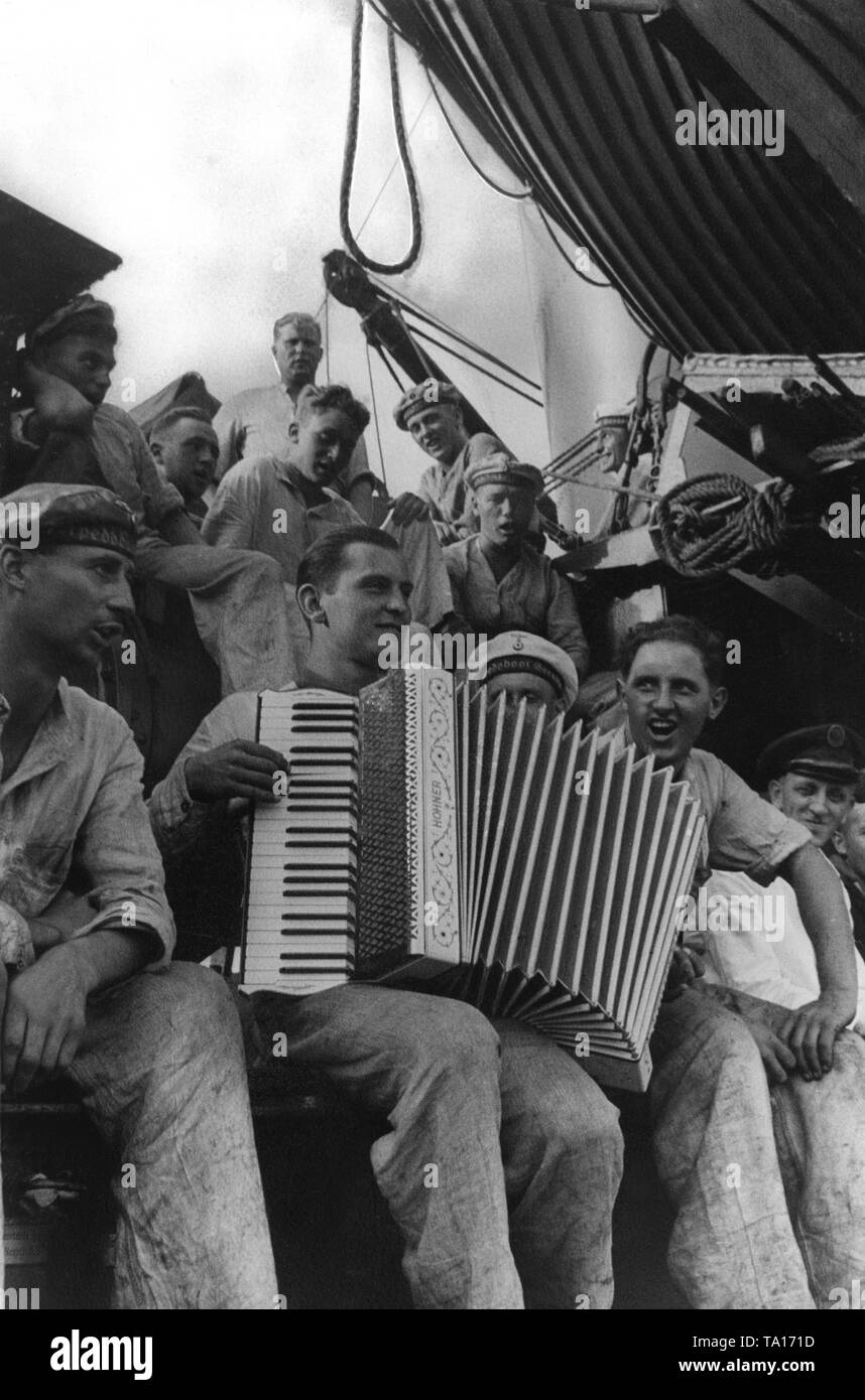 Matrosen der Kriegsmarine haben um ein Genosse mit Akkordeon gesammelt ...