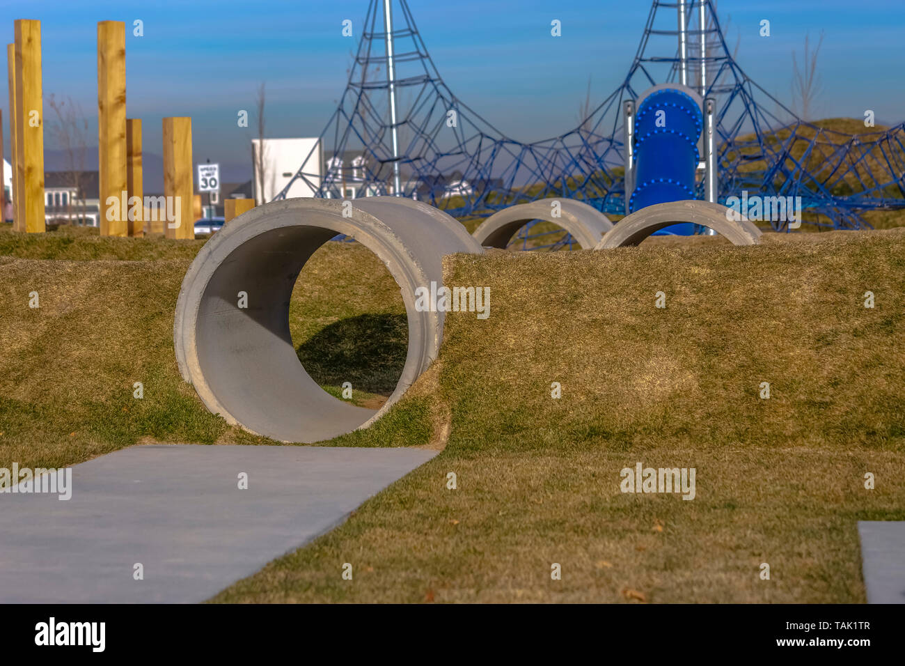 Spielplatz mit Tunnels aus Beton Rohre auf dem Grünen Hügel. Ein Seil ...