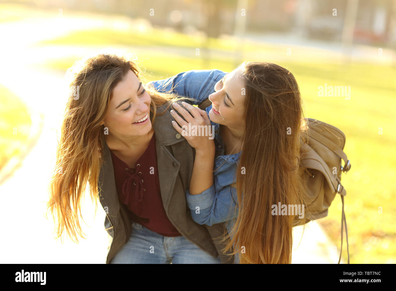 Lustige Freunde treffen und scherzen in der Straße am Sonnenuntergang ...