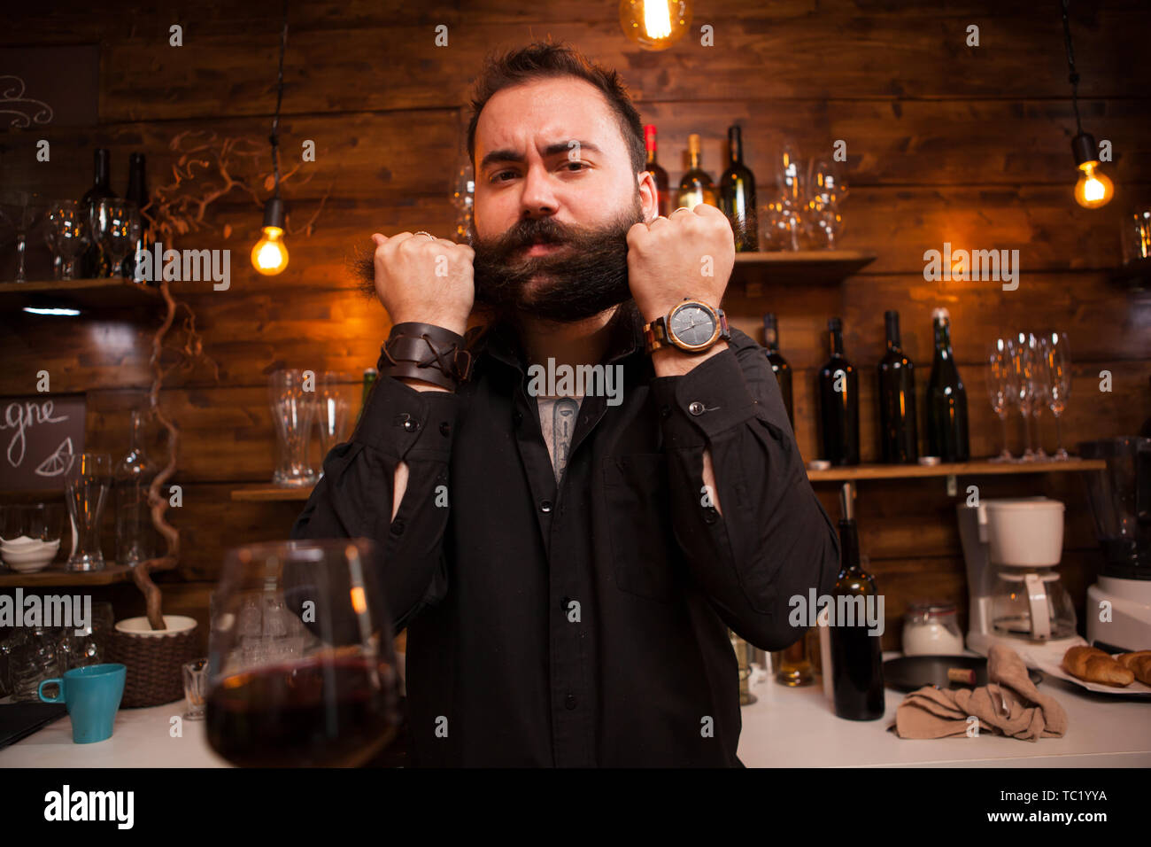 Bärtige Barkeeper, lustig mit seinem Bart hinter der Theke ...