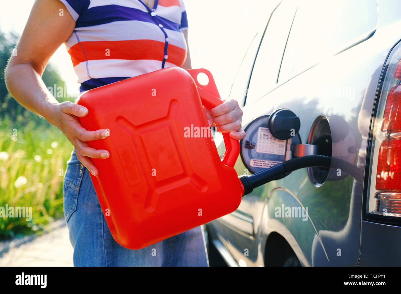 Eine Frau füllt das Auto mit Benzin aus dem Tank. Kanister 10 Liter ...