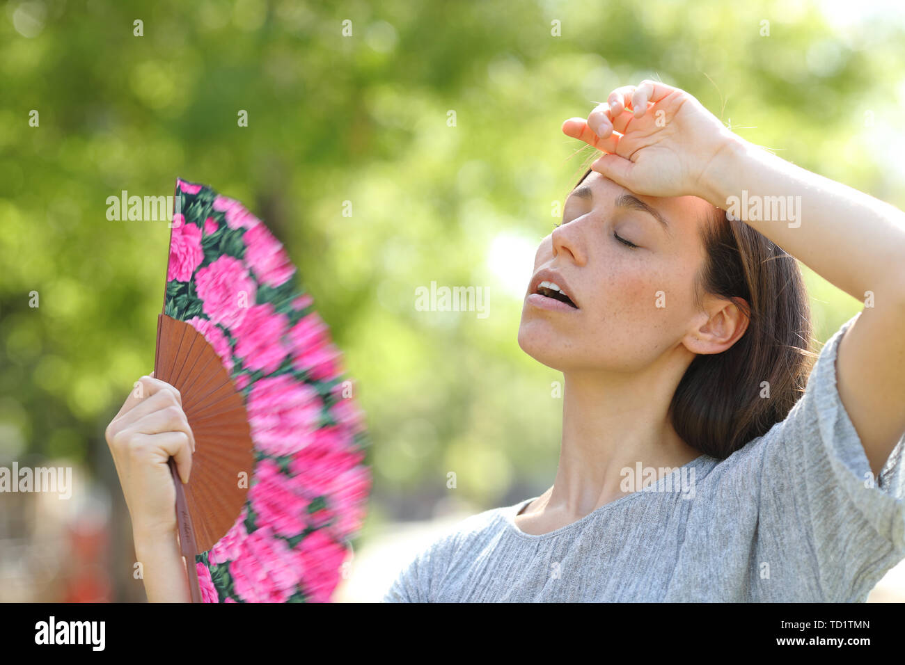 Betonte Frau fanning Leiden einen Hitzschlag an einem warmen Sommertag ...
