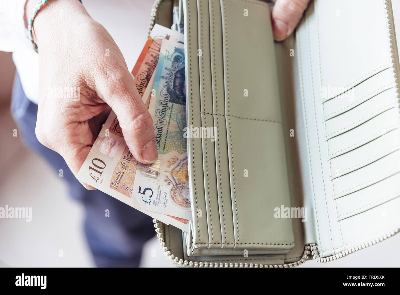 Frau, Die Geld Herausnimmt Stockfotos und -bilder Kaufen - Alamy