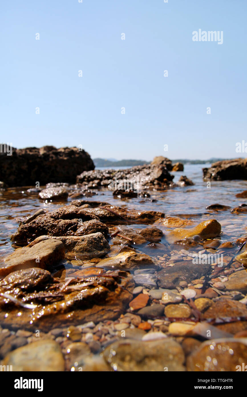 Exotische felsiger Strand mit bunten Steinen, tropischen blauen Meer ...