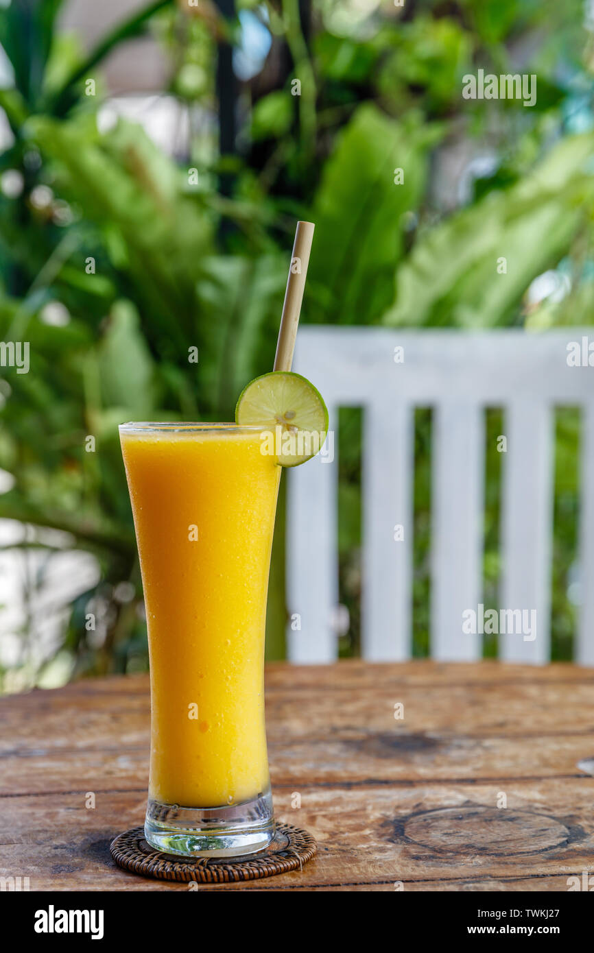 Mango Saft in ein hohes Glas mit Bambus Stroh, dekoriert mit Kalk ...
