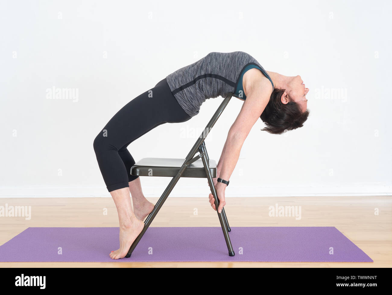 Eine 70 Jahre alte Frau Yoga Lehrer in ihrem Studio zeigt Iyengar Yoga ...