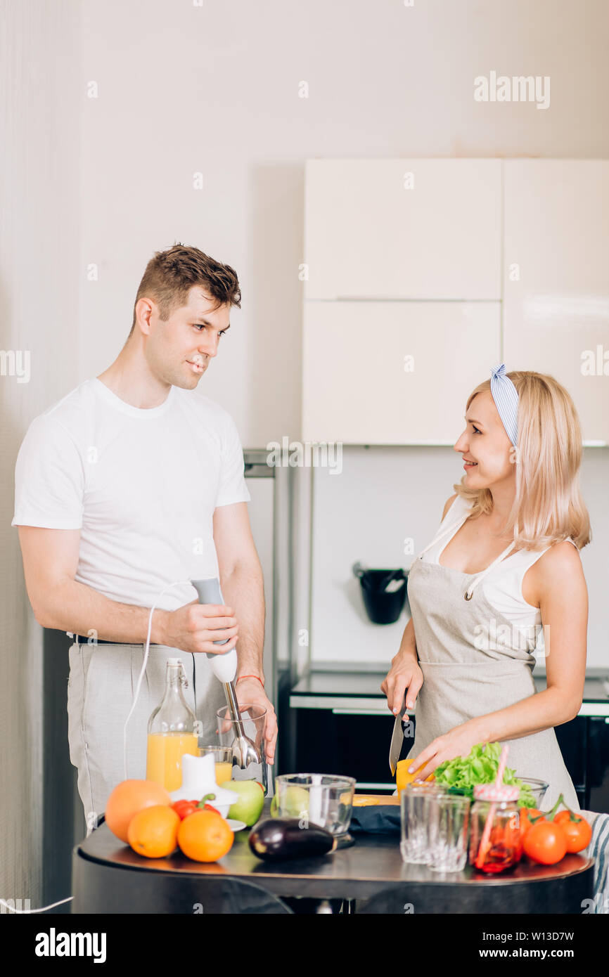 Glückliches junges Paar in Liebe kochen und Schneiden von Gemüse in der ...
