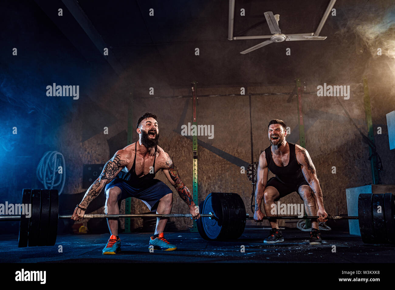 Zwei muskulösen Bärtigen tattoed Athleten training, Heben von schweren ...