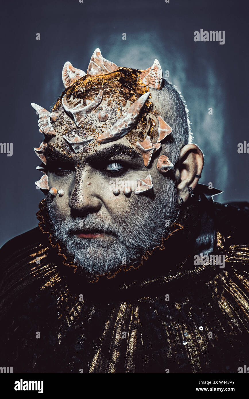 Dämon mit goldenen Kragen auf schwarzem Hintergrund. Mann mit Stacheln ...