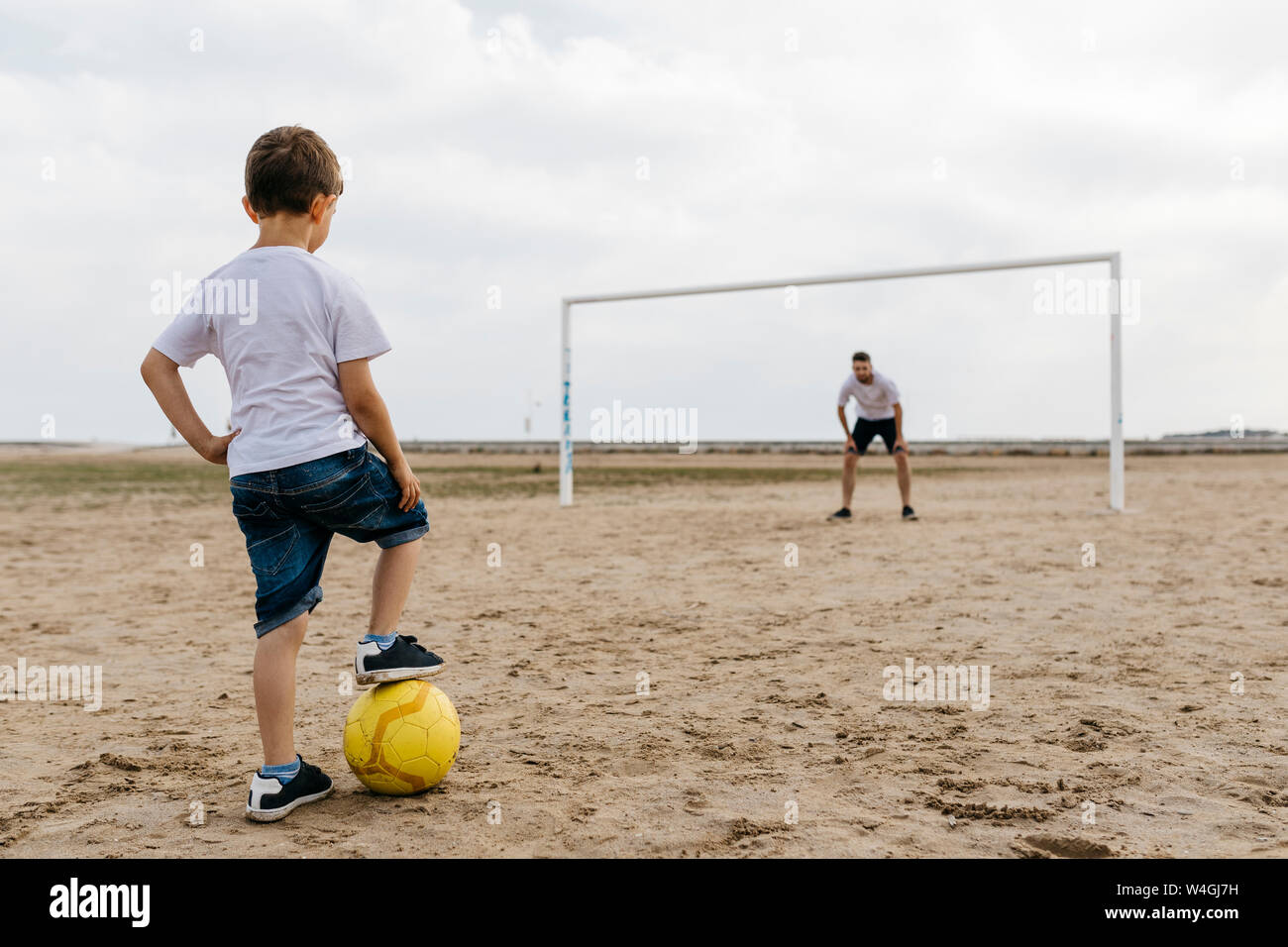 Mann Und Der Junge Fußball Spielen Am Strand Stockfotografie Alamy