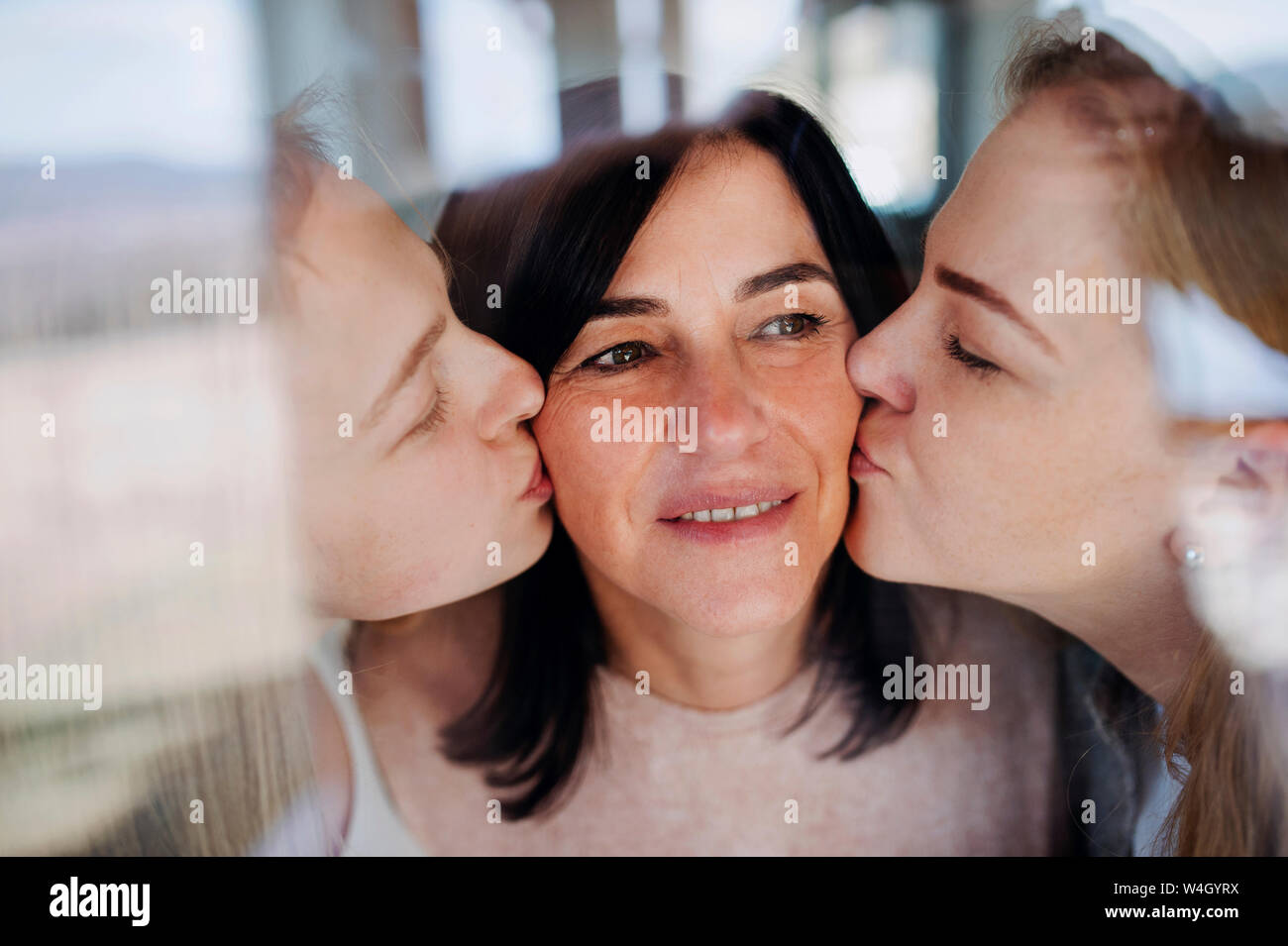 Besuchen Töchter küssen ihre Mutter, die im Fenster Stockfotografie - Alamy